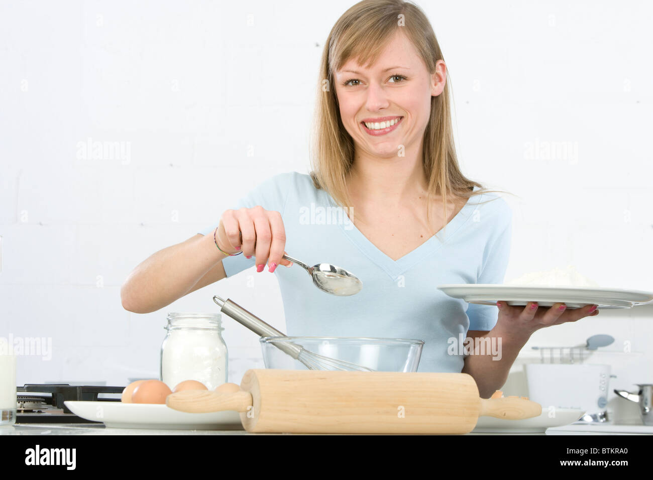 Beautiful woman in kitchen is making a cake Stock Photo - Alamy