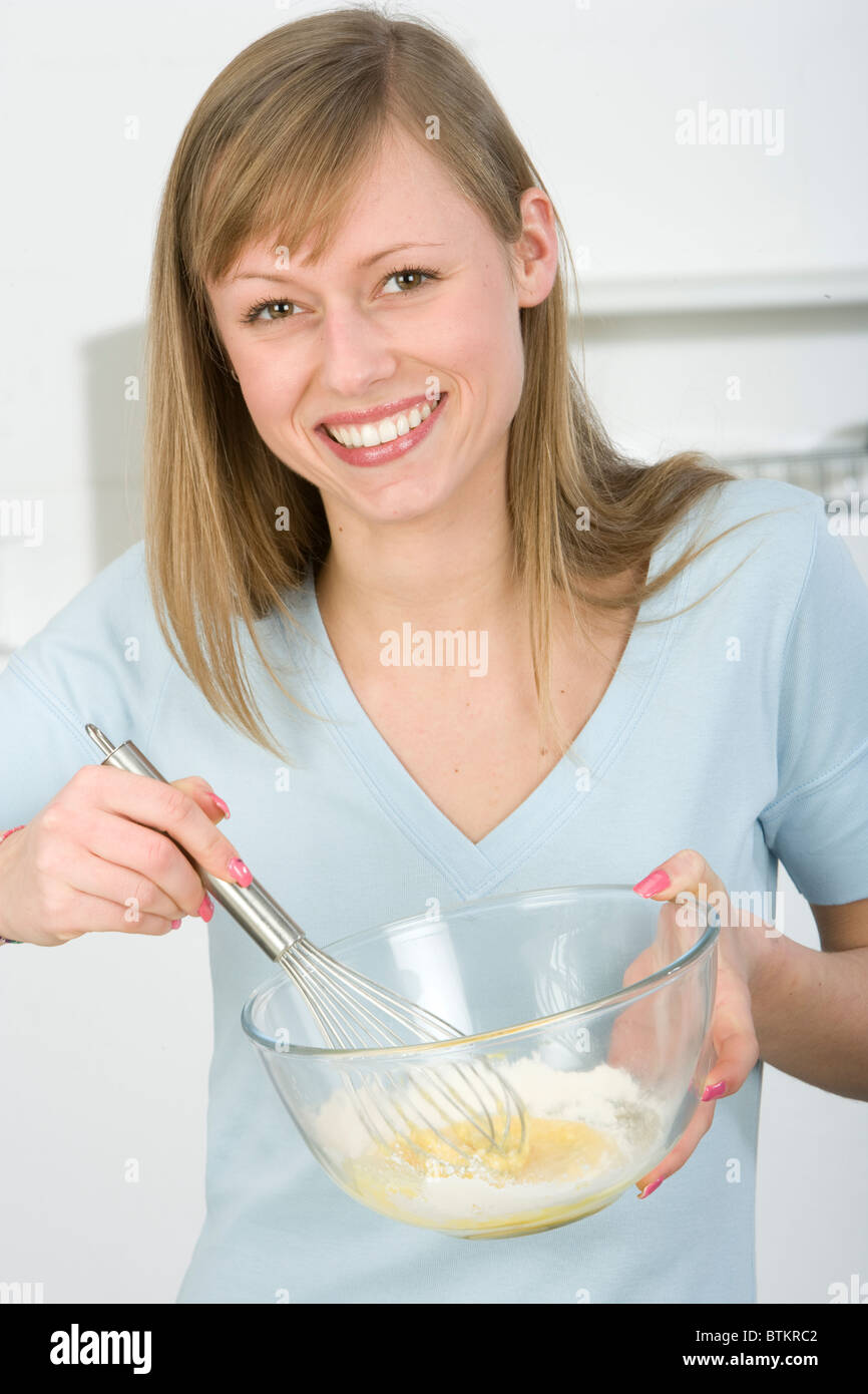Beautiful woman in kitchen is making a cake Stock Photo - Alamy