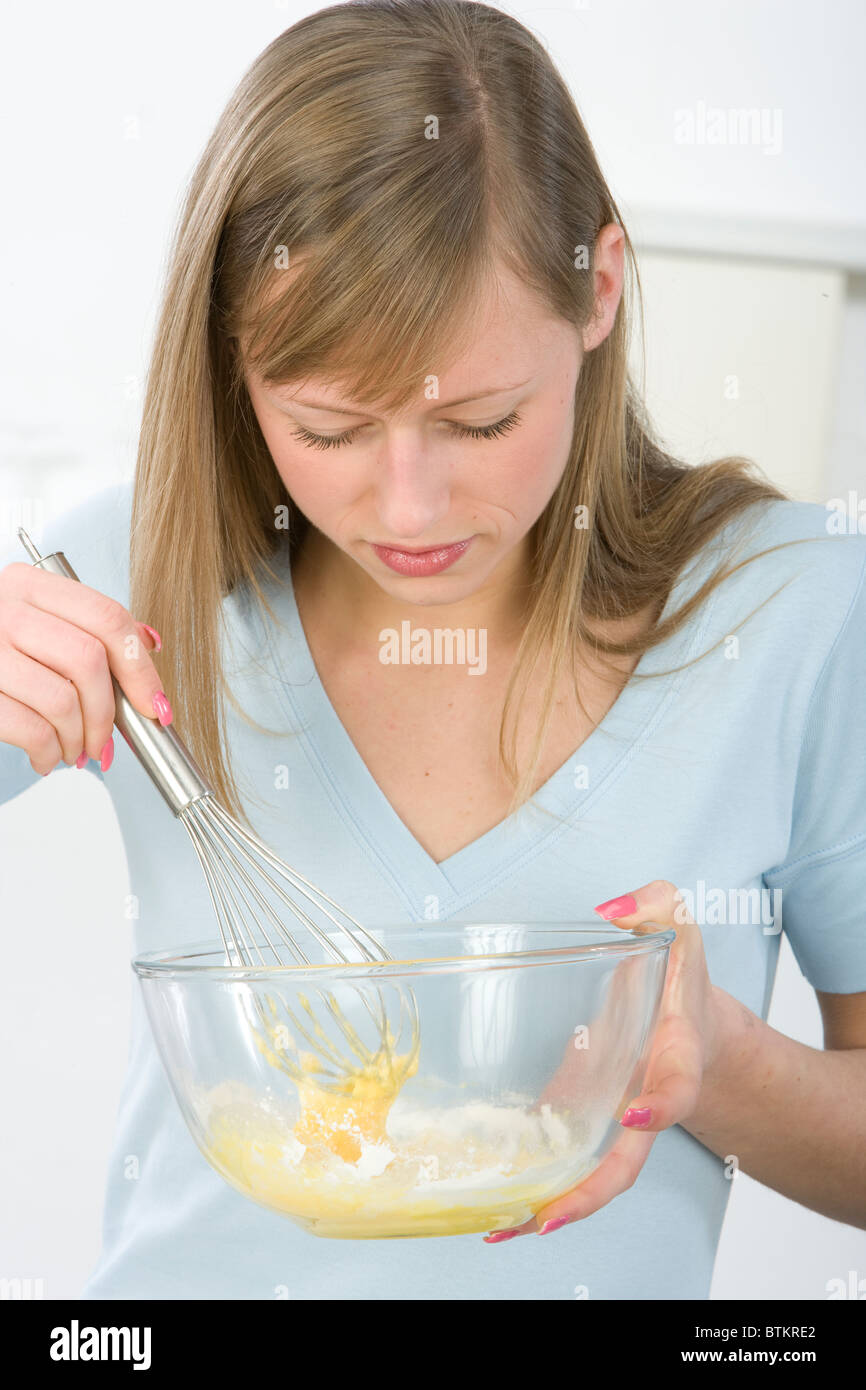 Beautiful woman in kitchen is making a cake Stock Photo - Alamy