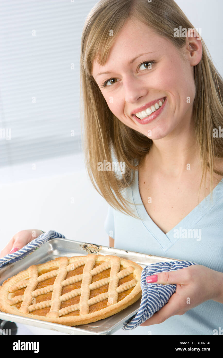 Beautiful woman in kitchen is making a cake Stock Photo - Alamy