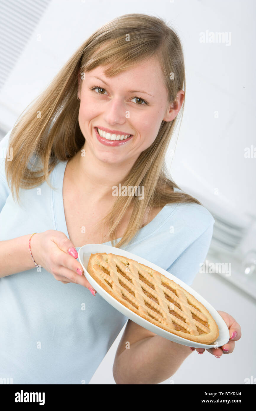Beautiful woman in kitchen is making a cake Stock Photo - Alamy