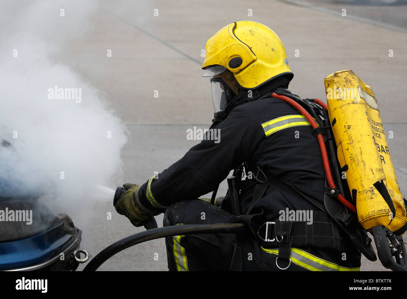 Fire fighter using a hose Stock Photo - Alamy