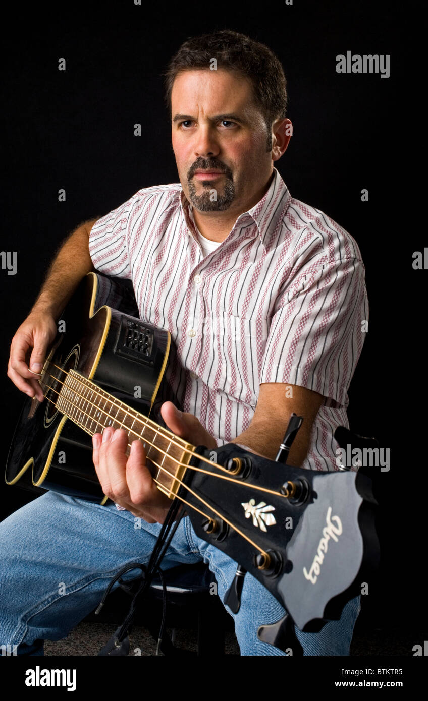 Musician in the spotlight playing the bass guitar Stock Photo - Alamy