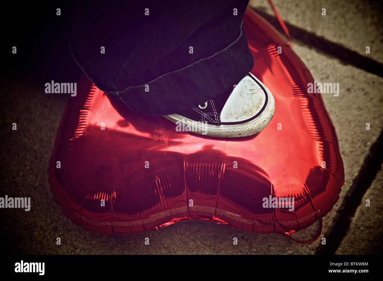foot on a heart balloon Stock Photo - Alamy