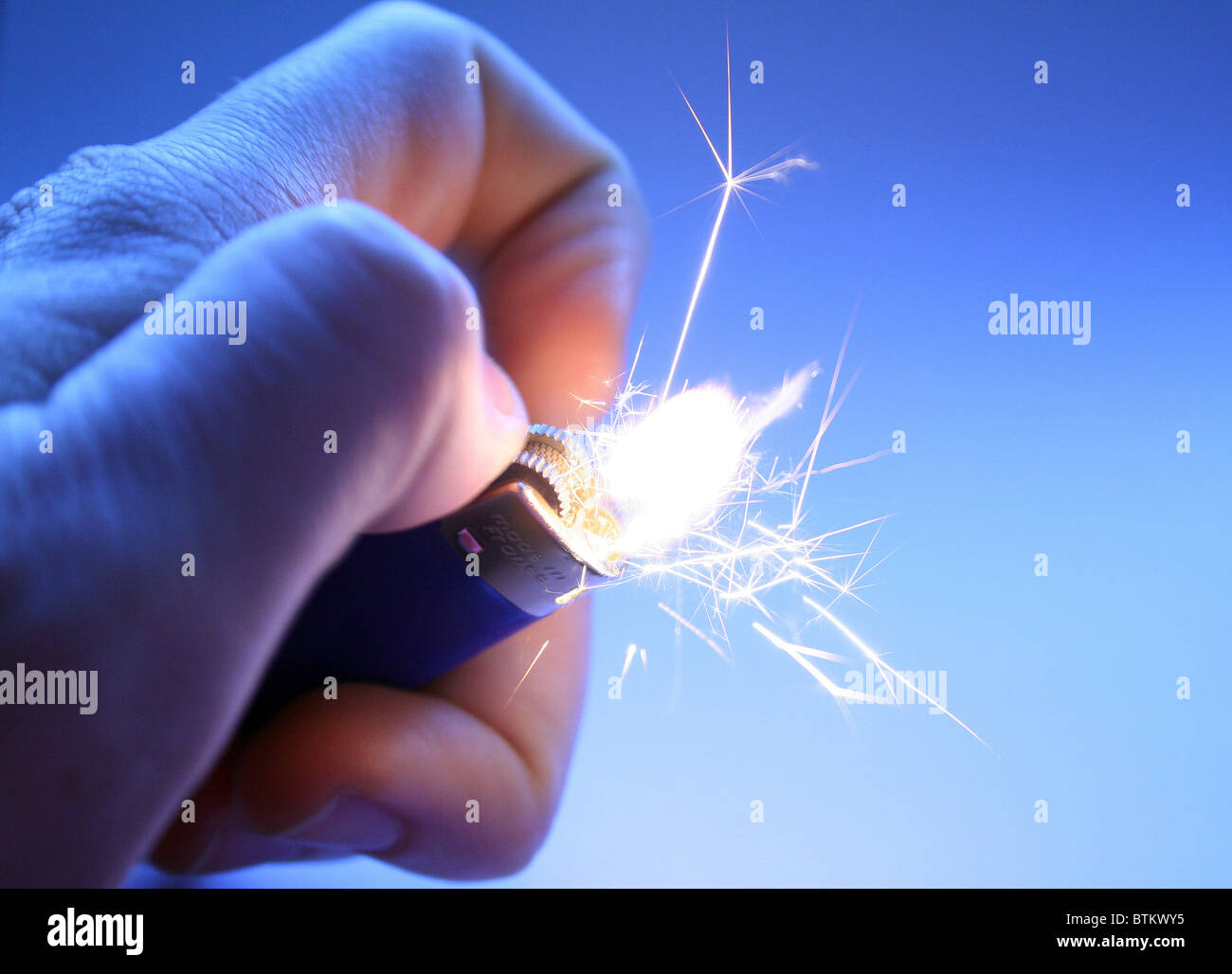 A small lighter in action to light a fire Stock Photo - Alamy