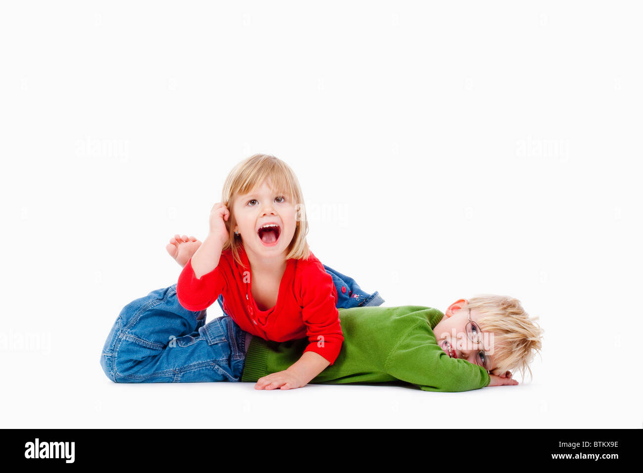 two young siblings fooling around with each other - isolated on white ...