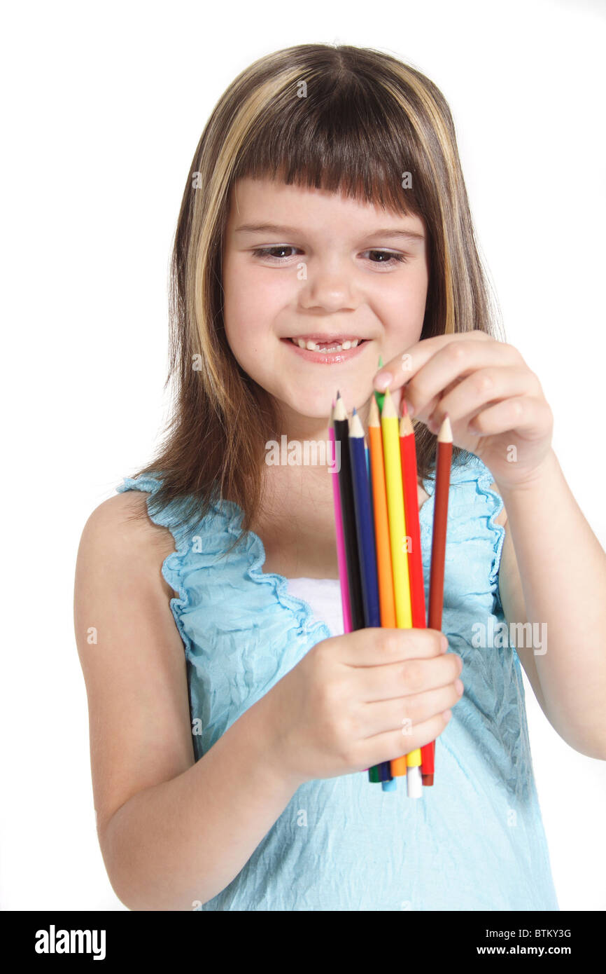 A young girl choosing a colorful crayon. All isolated on white ...