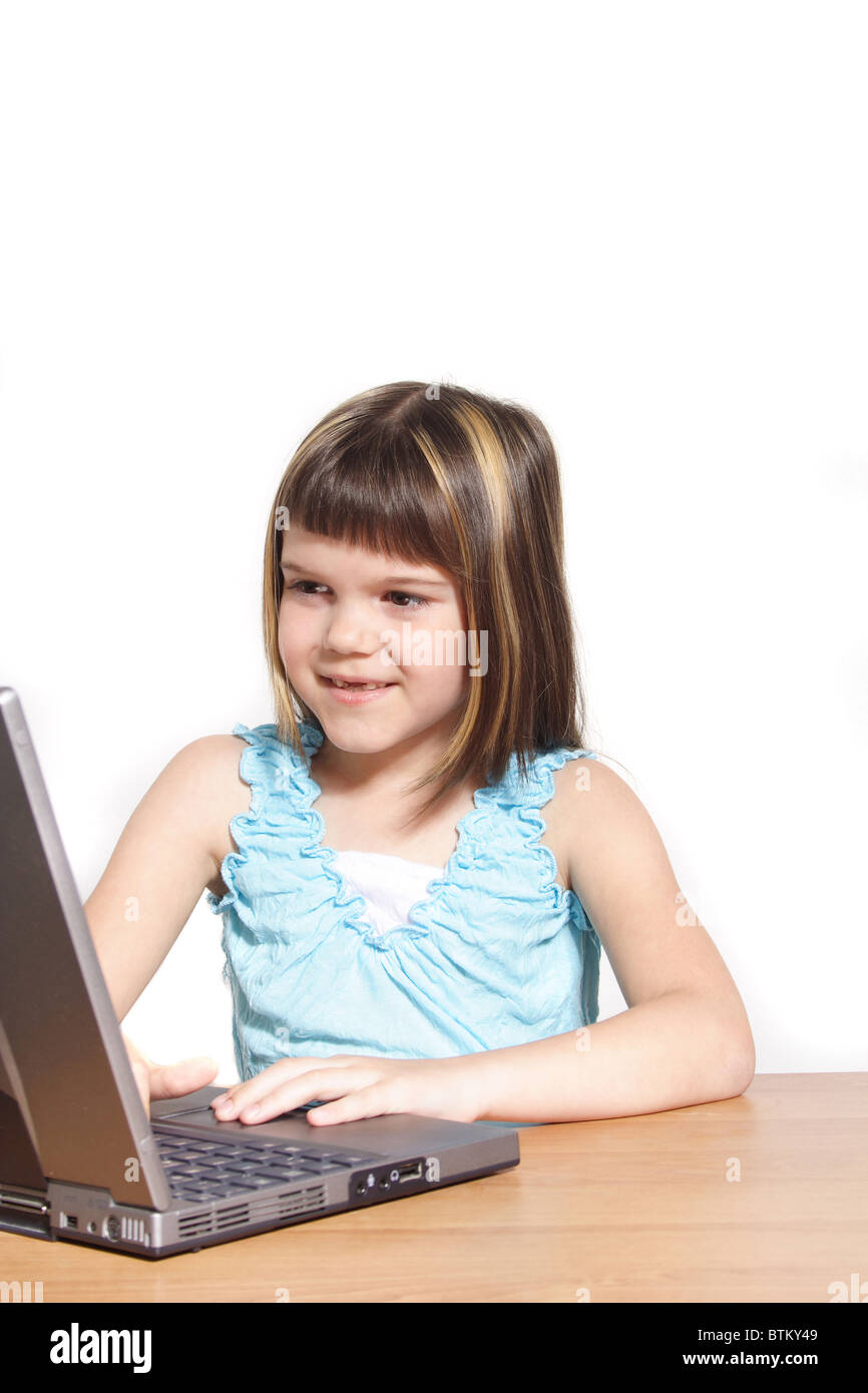 A young girl using a notebook computer. All isolated on white ...
