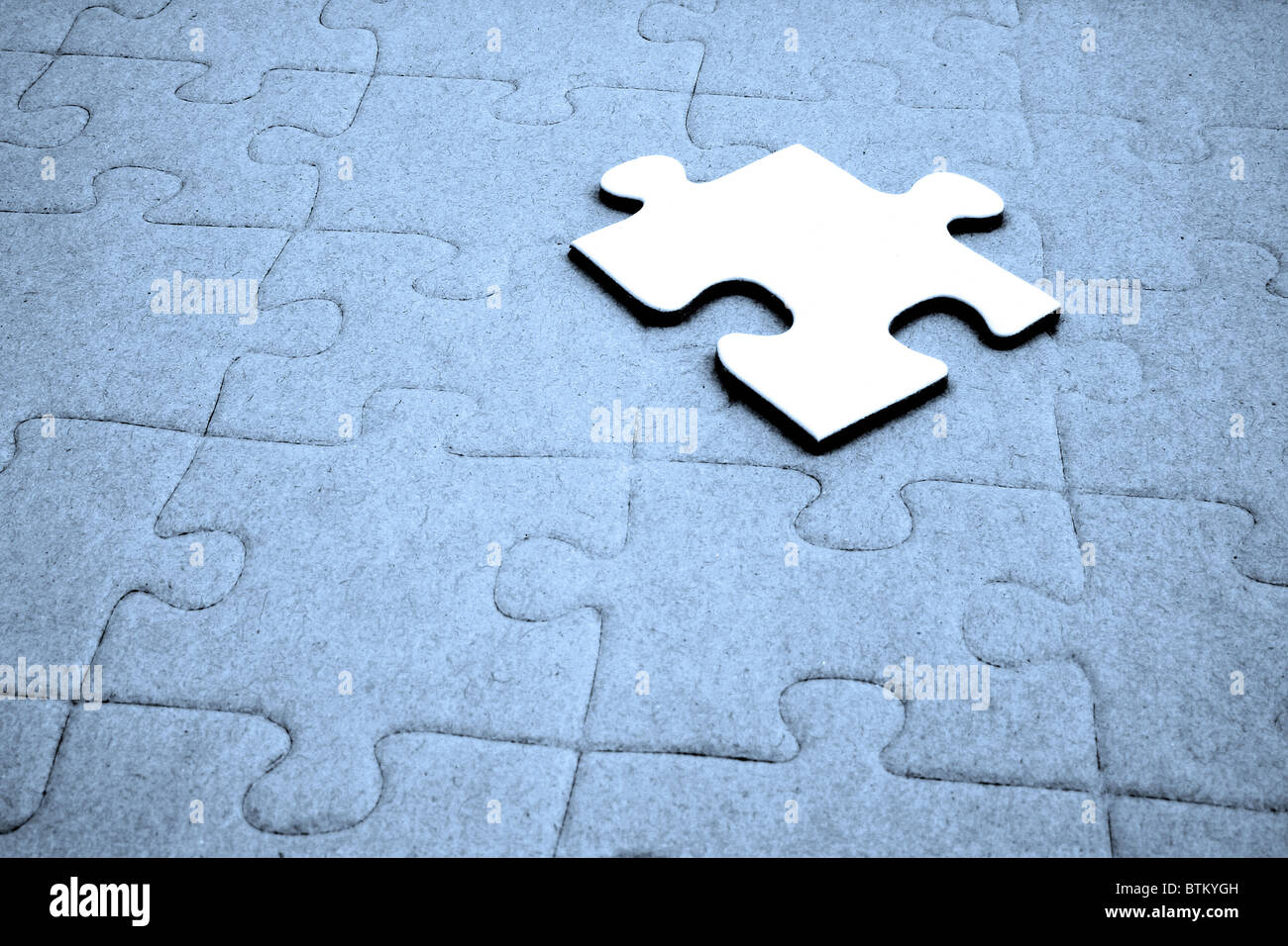 A typical jigsaw puzzle with a single piece on top Stock Photo - Alamy