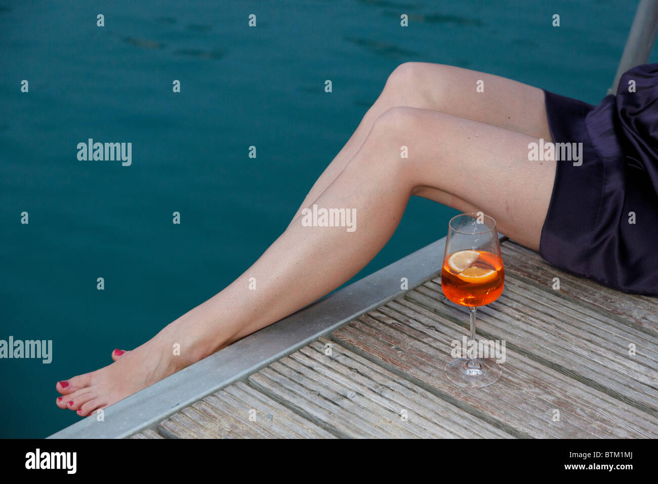 woman sitting on landing stage with Aperol Sprizz Stock Photo - Alamy