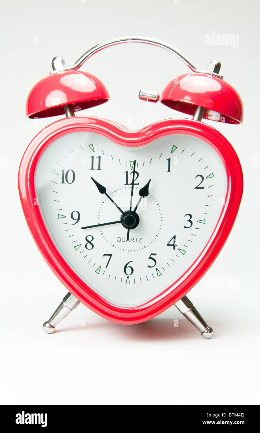 Heart shaped red alarm clock Stock Photo - Alamy