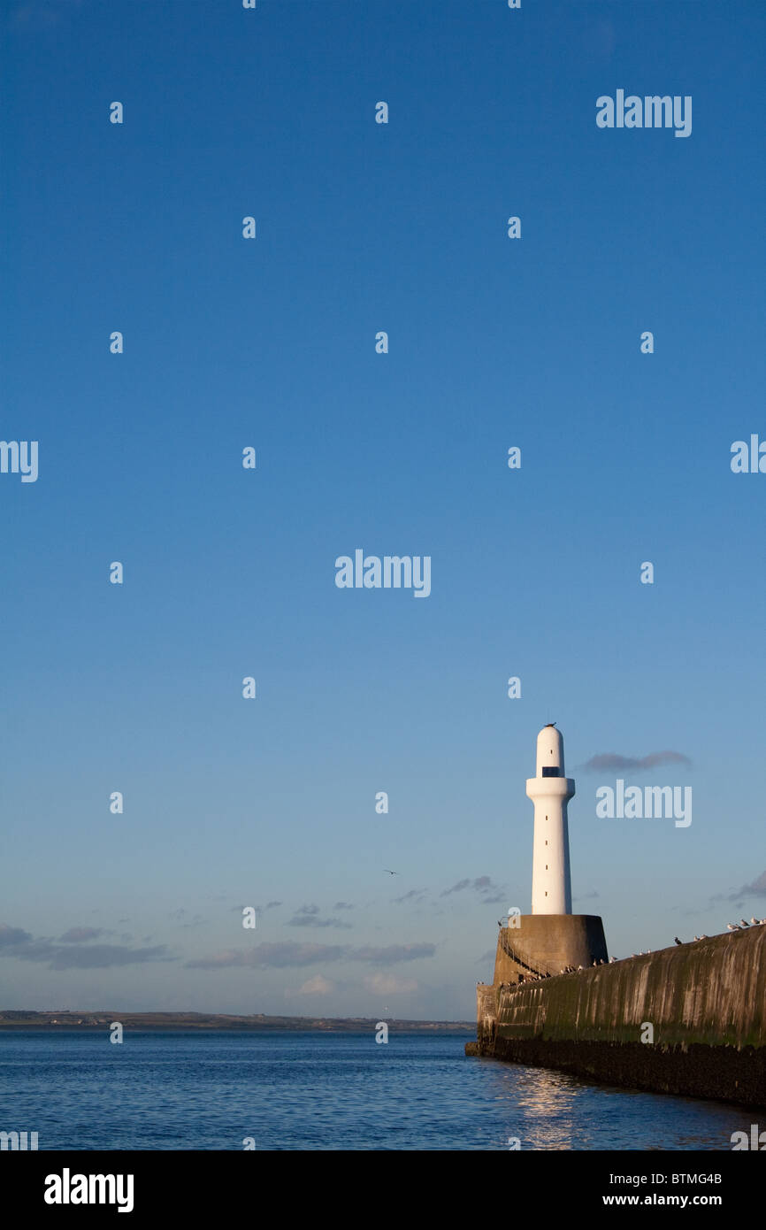 lighthouse and harbour wall on a clear sunny day and calm sea Stock ...
