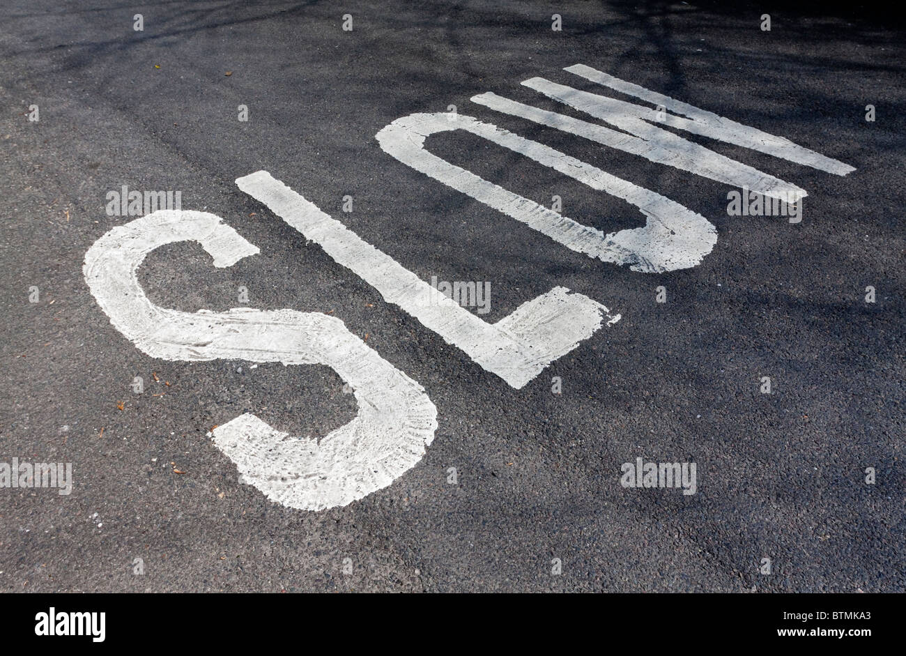 Slow sign painted on black tarmac on a country lane in the UK Stock ...