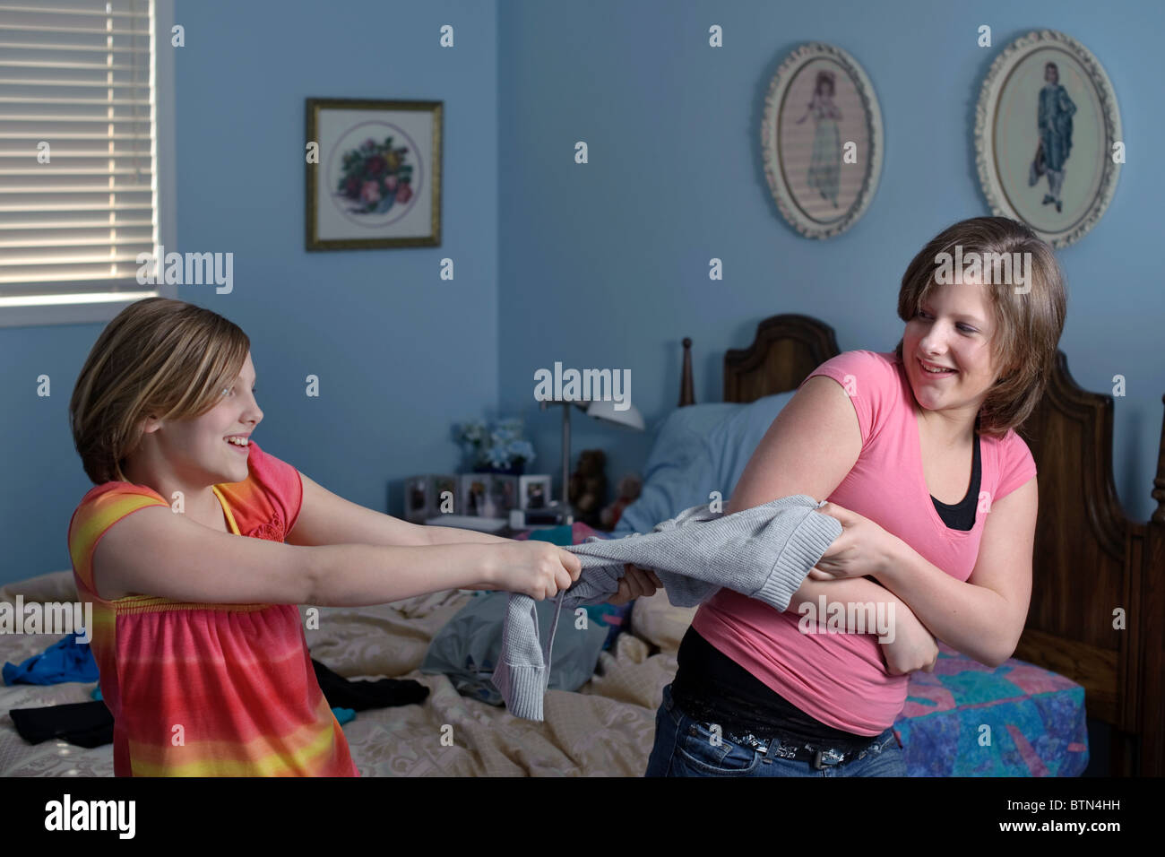 two young sisters fighting over some clothing Stock Photo - Alamy