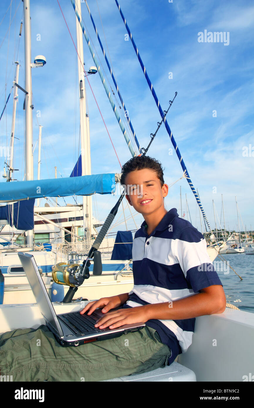boy teenager seat on boat marina laptop computer summer vacation Stock ...