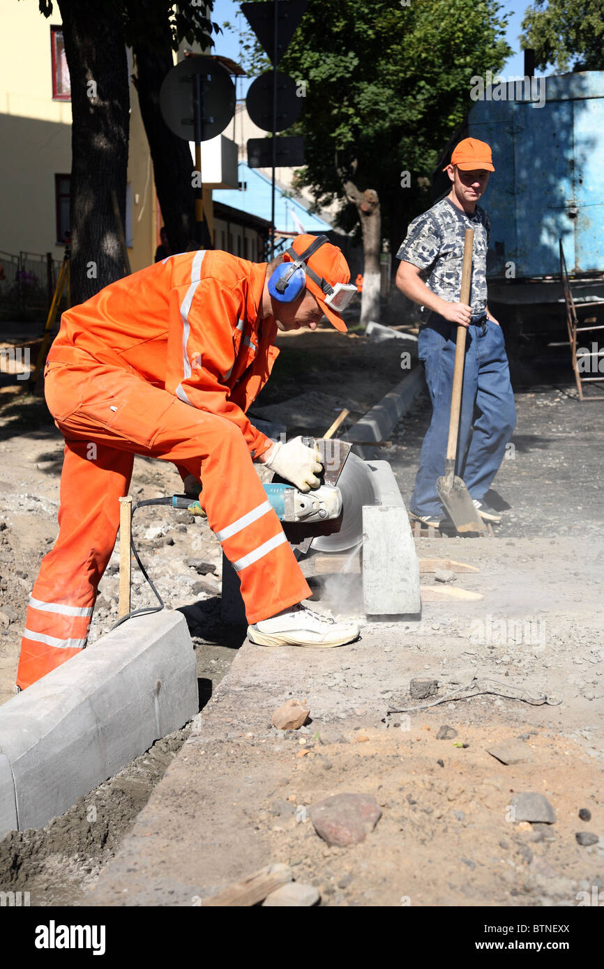 A road construction worker cutting stone for the kerb, Brest, Belarus ...