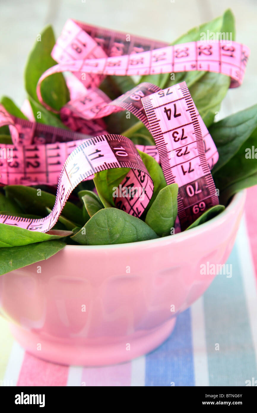 Spinach diet with a pink measuring tape Stock Photo - Alamy