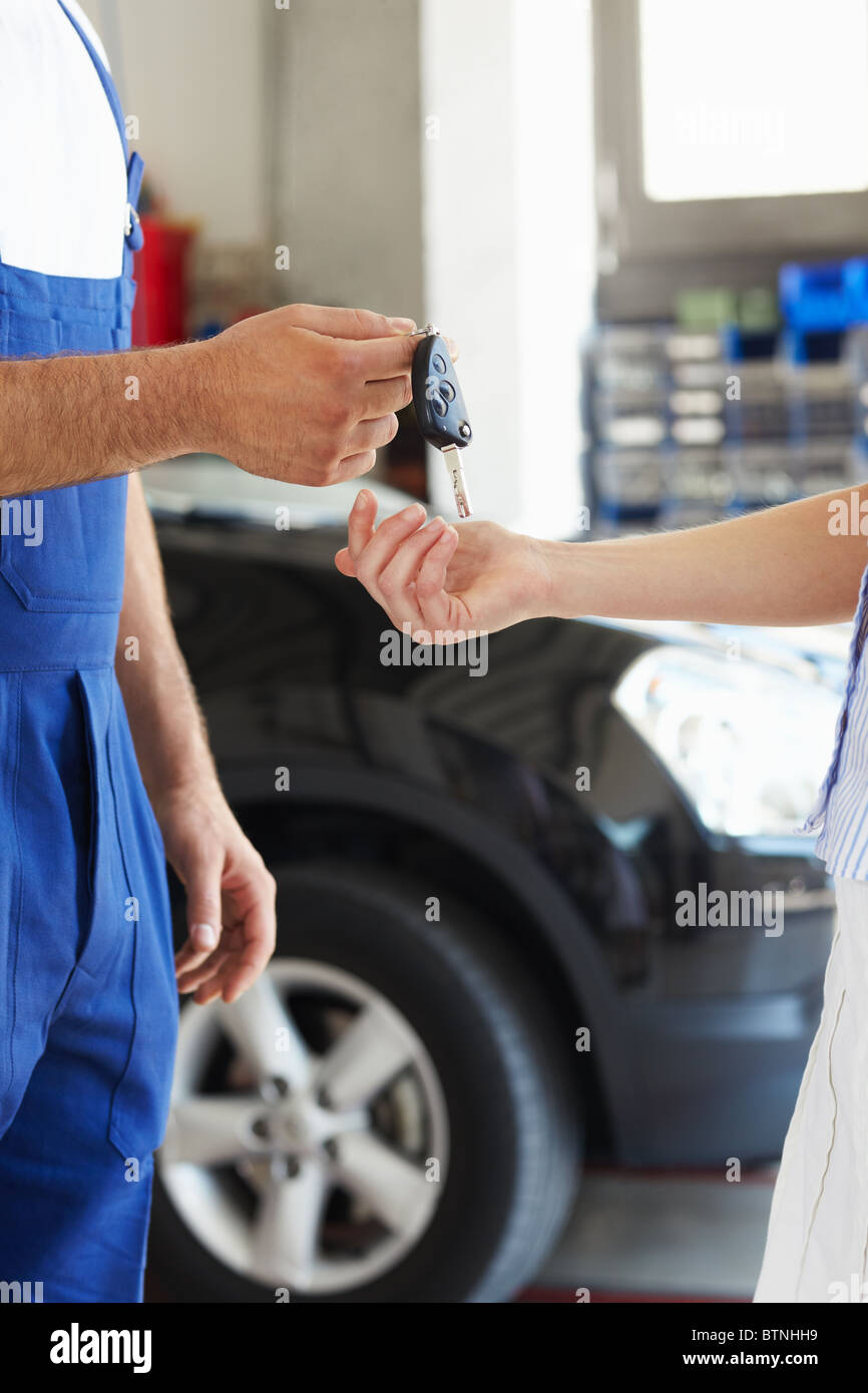 cropped view of mechanic giving car keys to female client Stock Photo ...