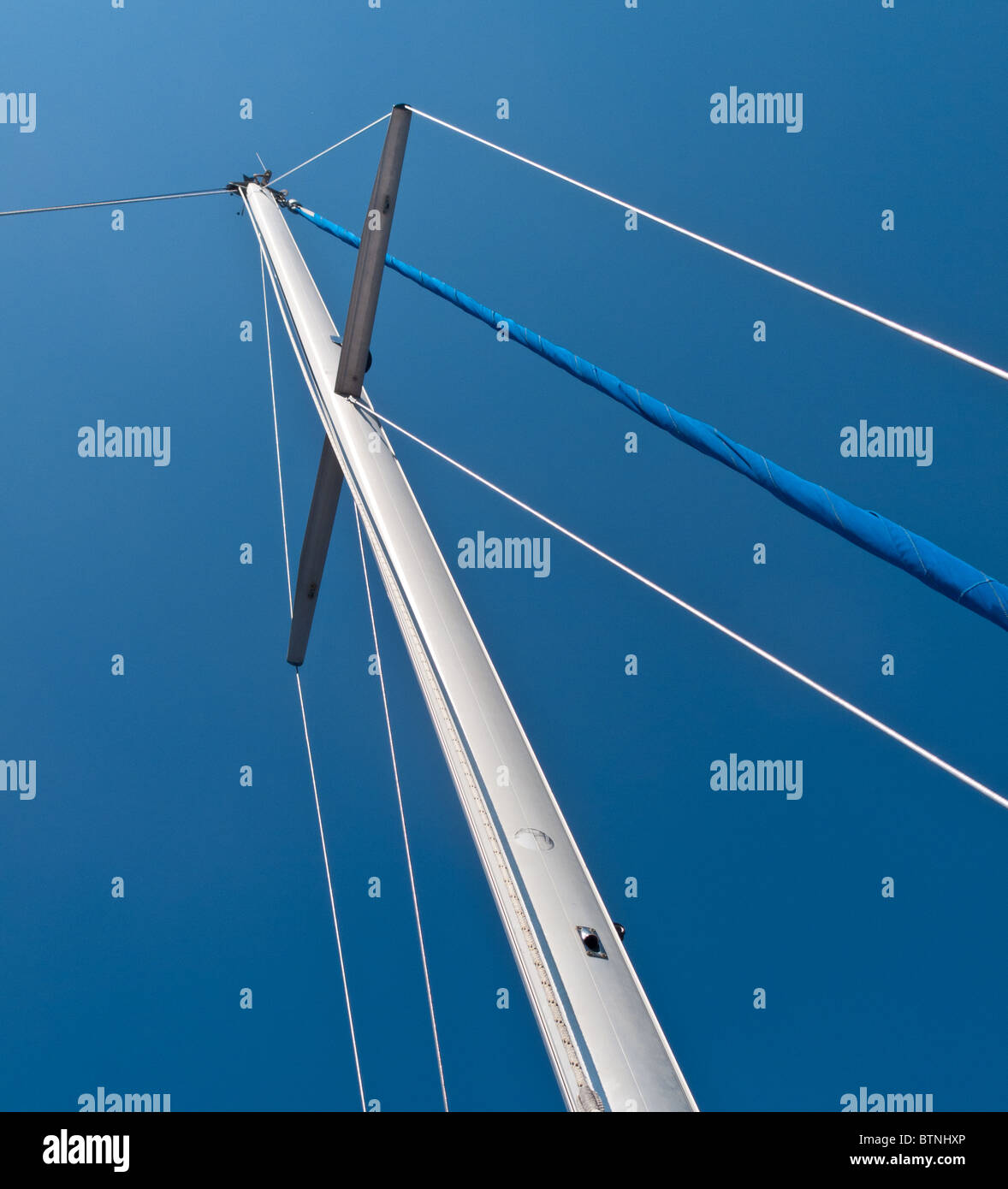 Detail of mast, wires and rigging on yacht against a deep blue sky ...