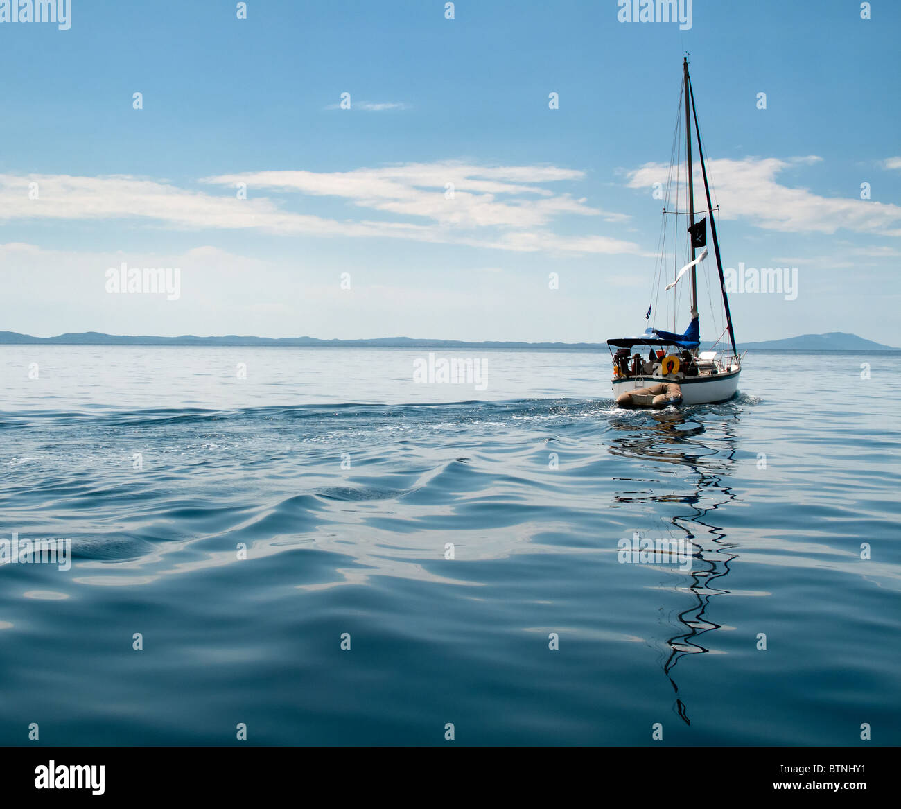 Yacht with trailing dinghy on the calm seas of the Mediterranean Stock ...