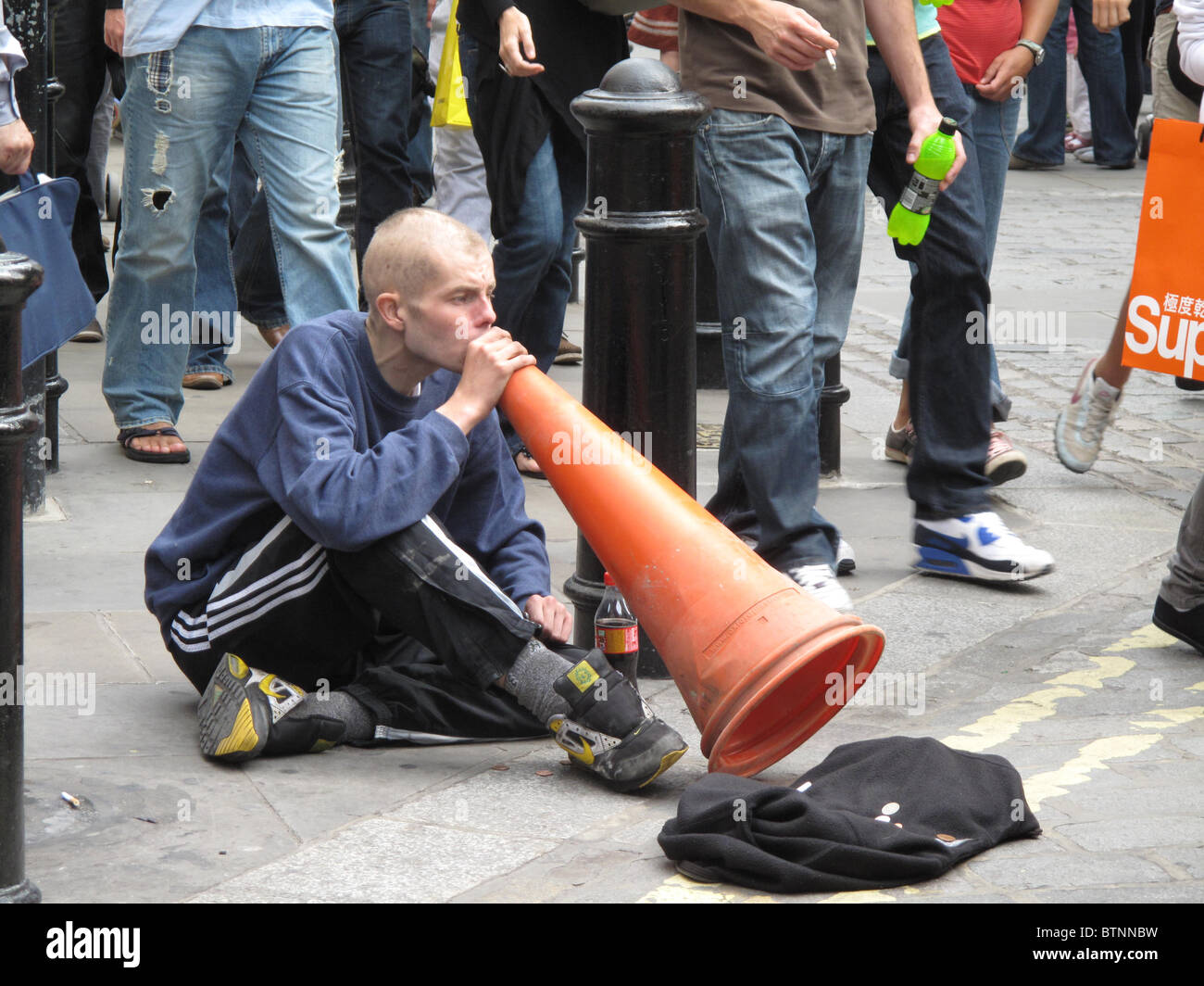 On the street in Covent Garden.Man using a traffic cone to busk Stock ...