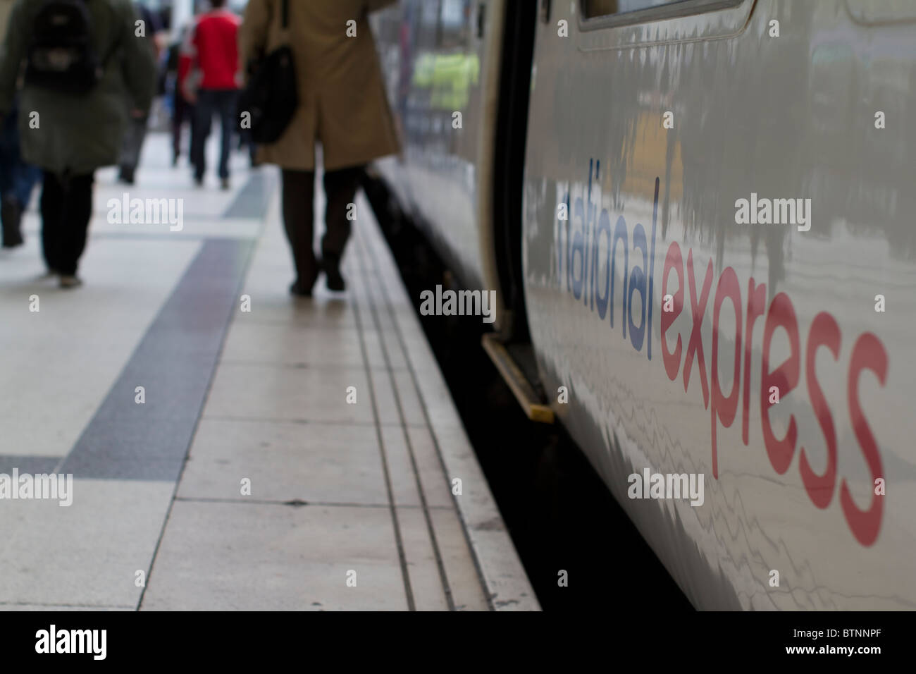 Commuters walking past National Express train on platform at Liverpool ...