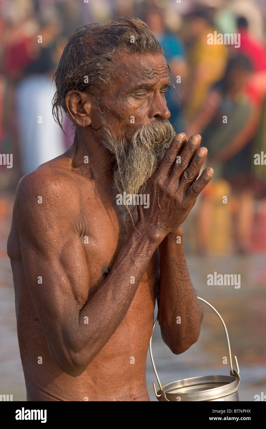 Male pilgrim with a long beard and moustache praying at the Ganga Sagar ...