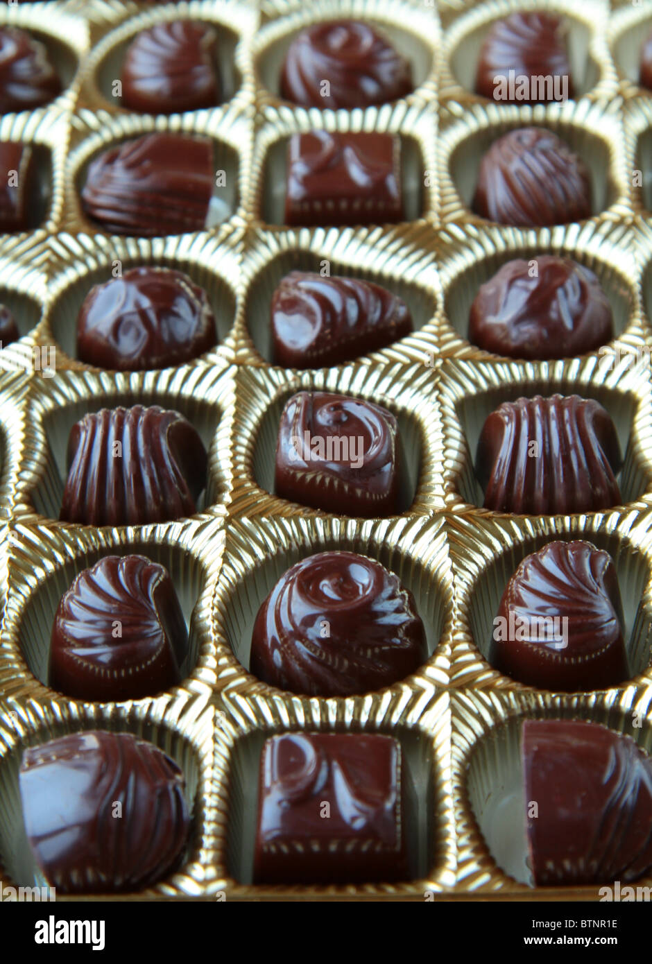 Many chocolates in a beautiful gold box Stock Photo - Alamy