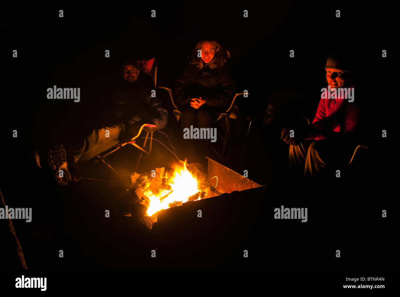 Family sitting around fire hi-res stock photography and images - Alamy