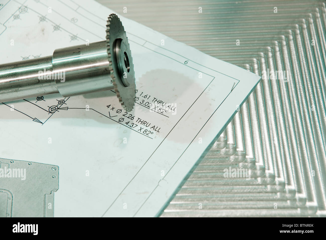 Metal tooling shop floor concept with CAD blueprint and drill bits ...