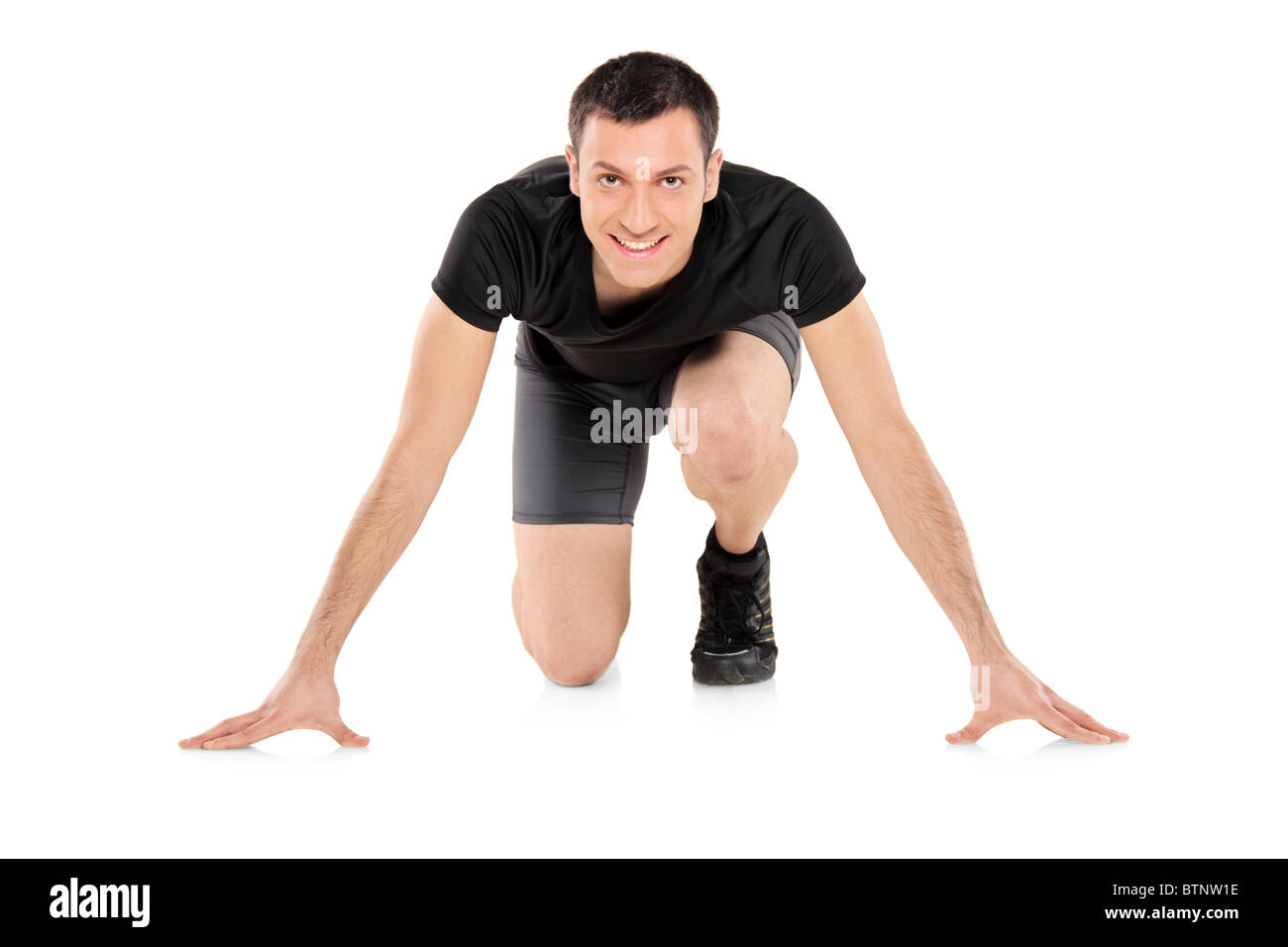 Full length portrait of a young man ready to run, looking at camera ...