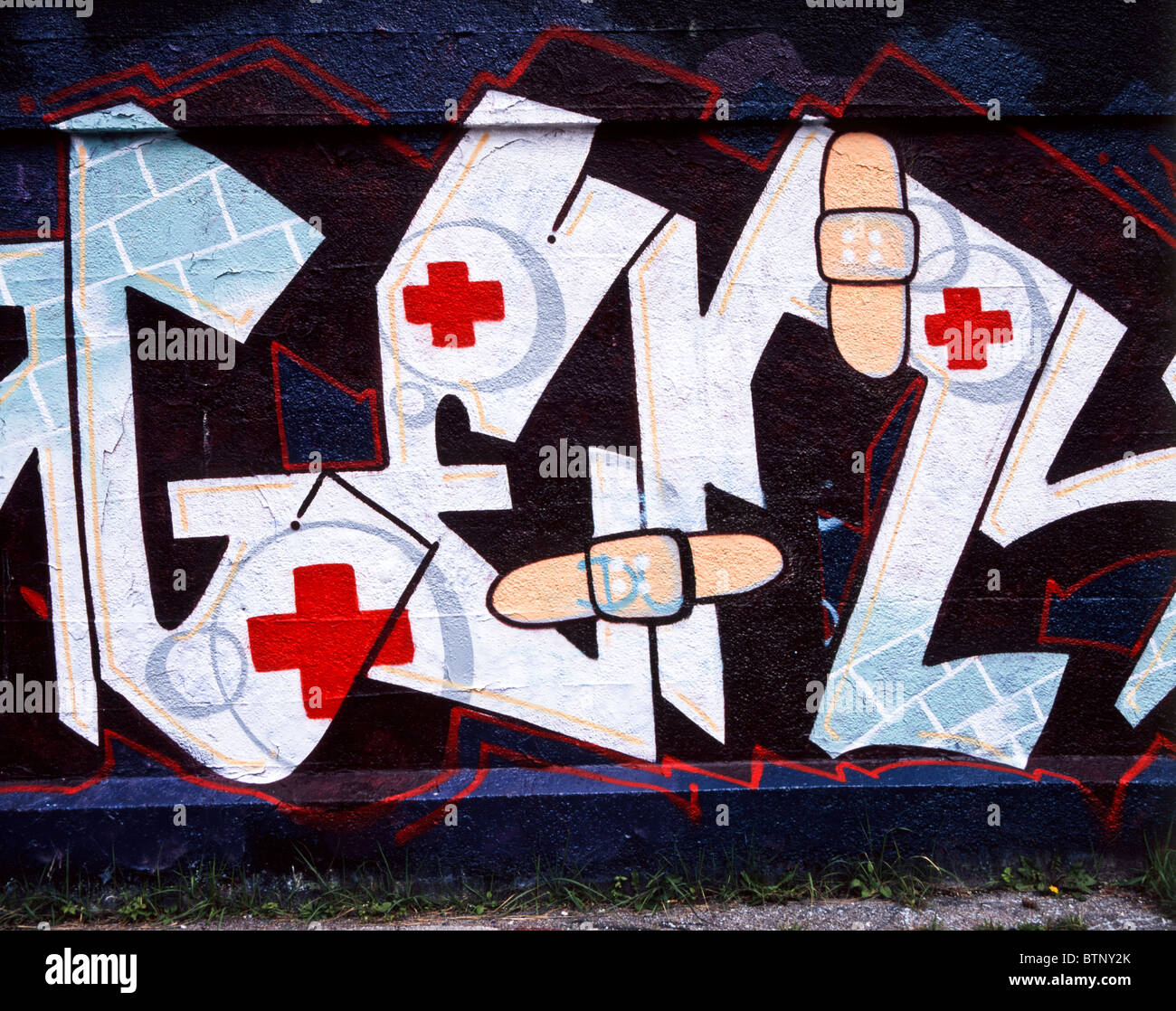 Graffiti showing red crosses and plasters / adhesive tapes on a wall in ...