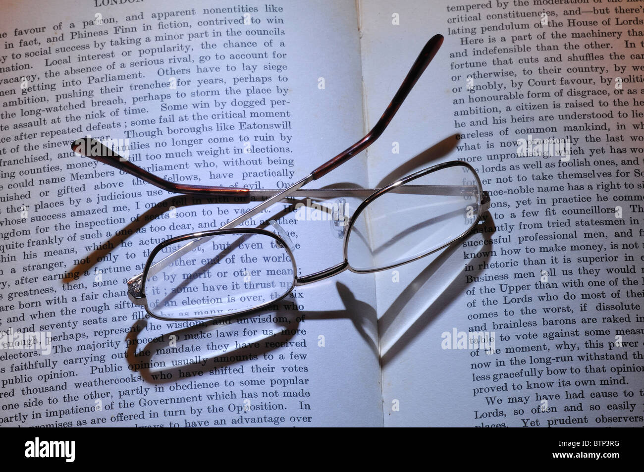 A pair of reading glasses on an open book. October 2010 Stock Photo - Alamy