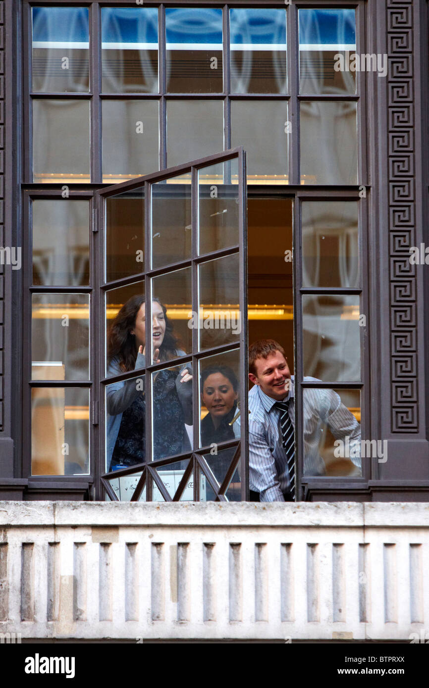Office workers look out of a window Stock Photo - Alamy