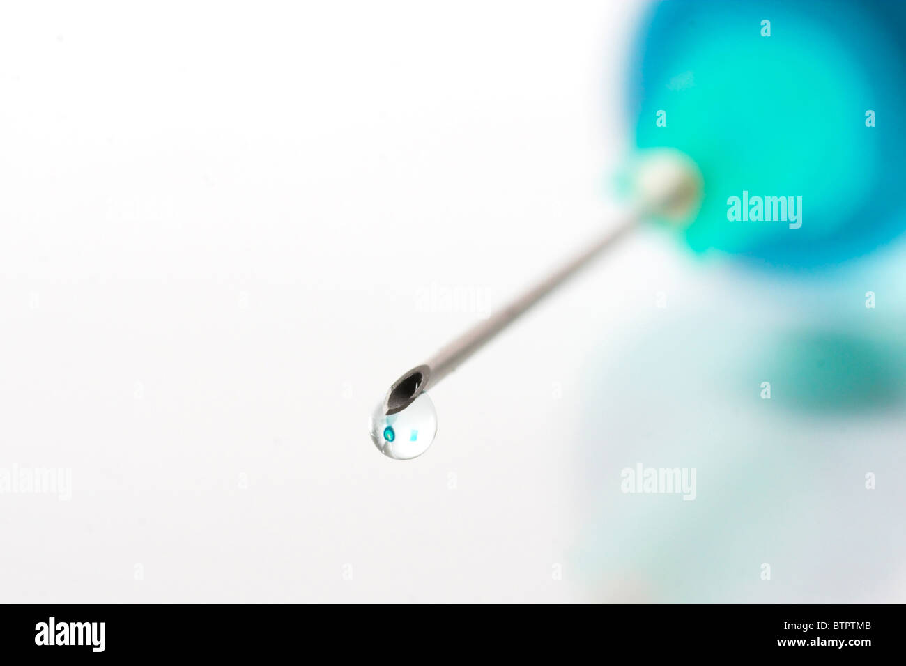 Drop of blue liquid on an injection needle Stock Photo - Alamy