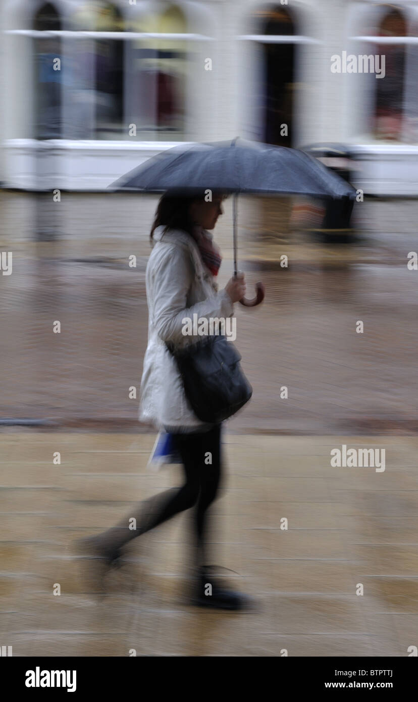 Woman walking with umbrella Stock Photo - Alamy