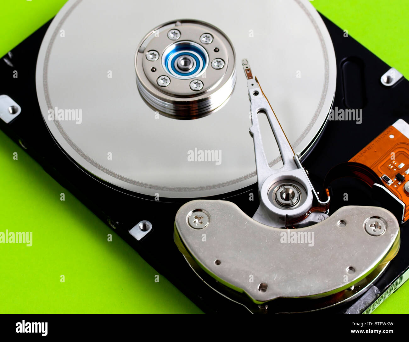 Open hard disk drive in a green background Stock Photo - Alamy