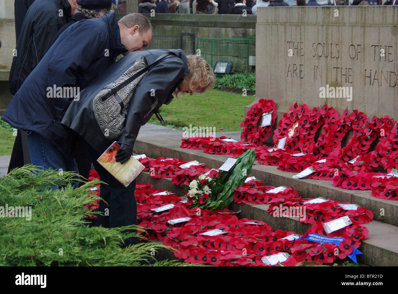 A couple examine the inscriptions on wreaths at a Remembrance Sunday ...