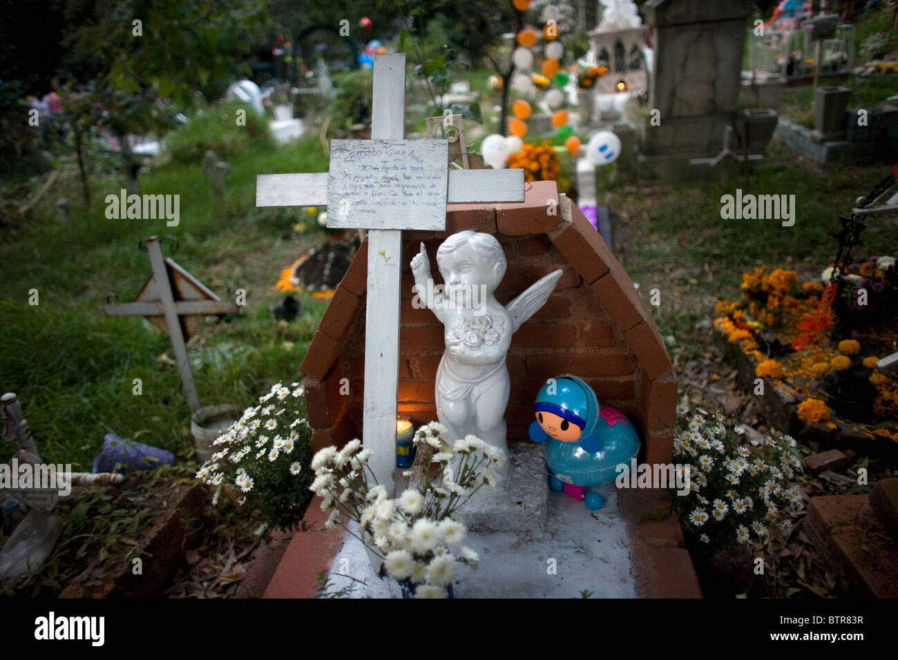 A blue toy and an angel decorate a tomb at the cemetery in Jilotepec ...