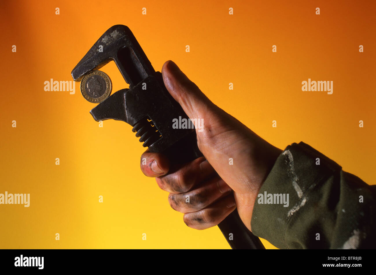 conceptual image of mechanic with oily hand holding adjustable spanner ...