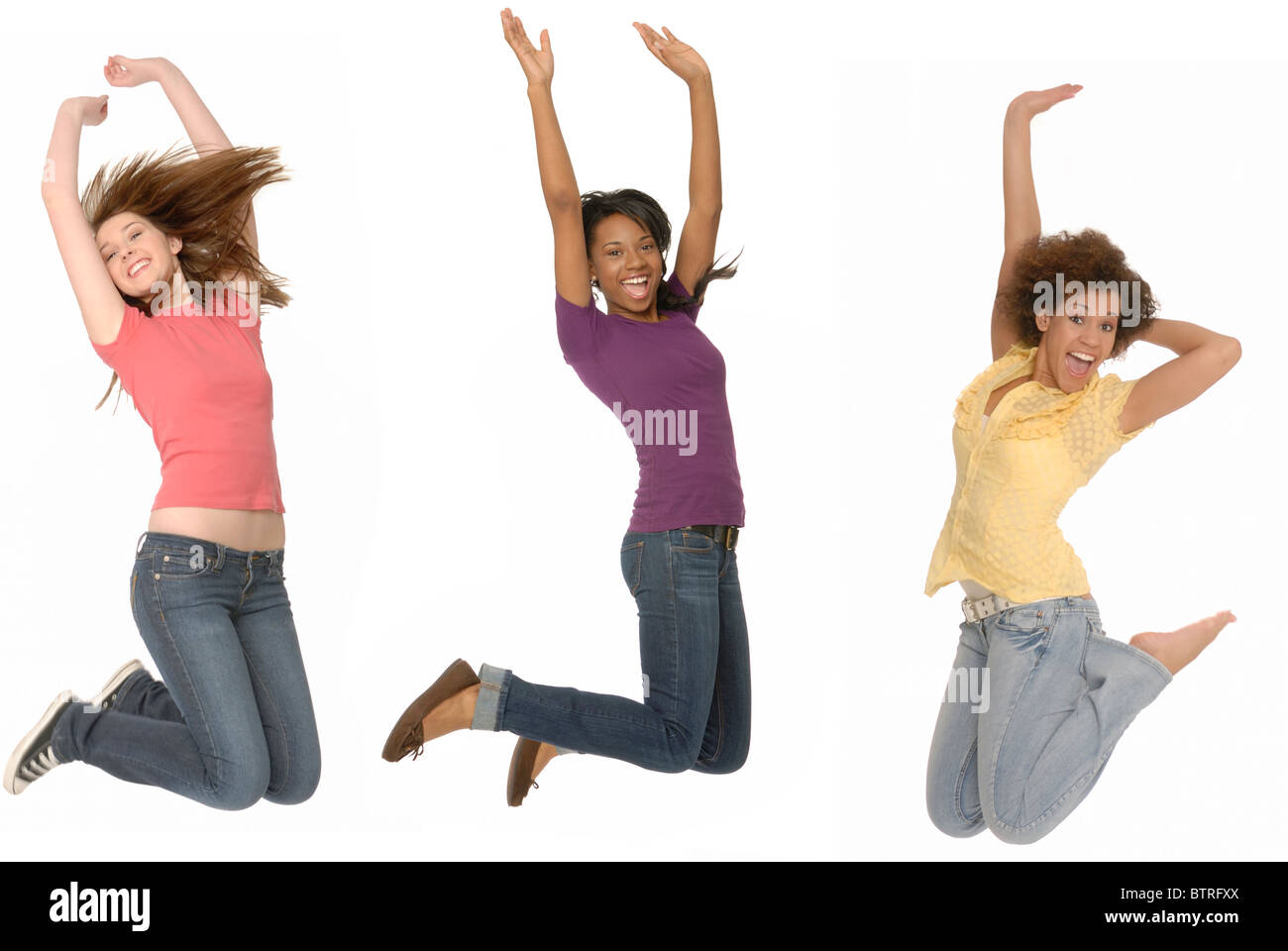 Three teenage girls jumping in the air with arms up, on solid white ...
