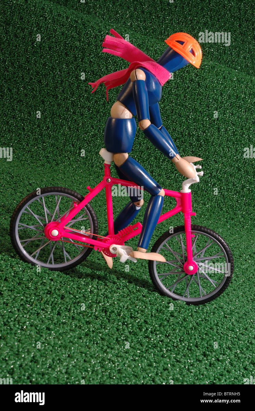 Wooden artists model figure riding a toy bicycle Stock Photo - Alamy