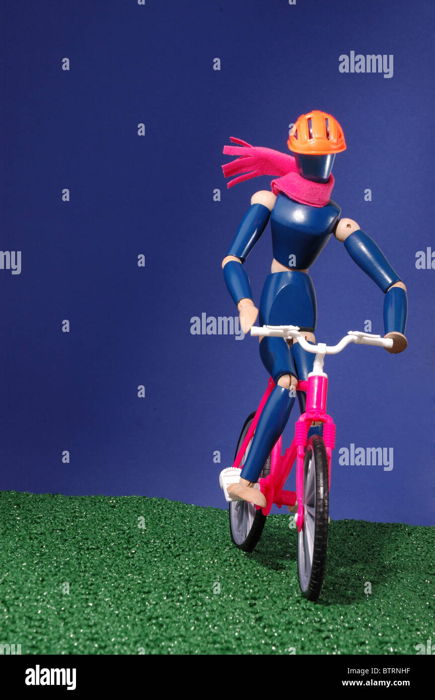 Wooden artists model figure riding a toy bicycle Stock Photo - Alamy
