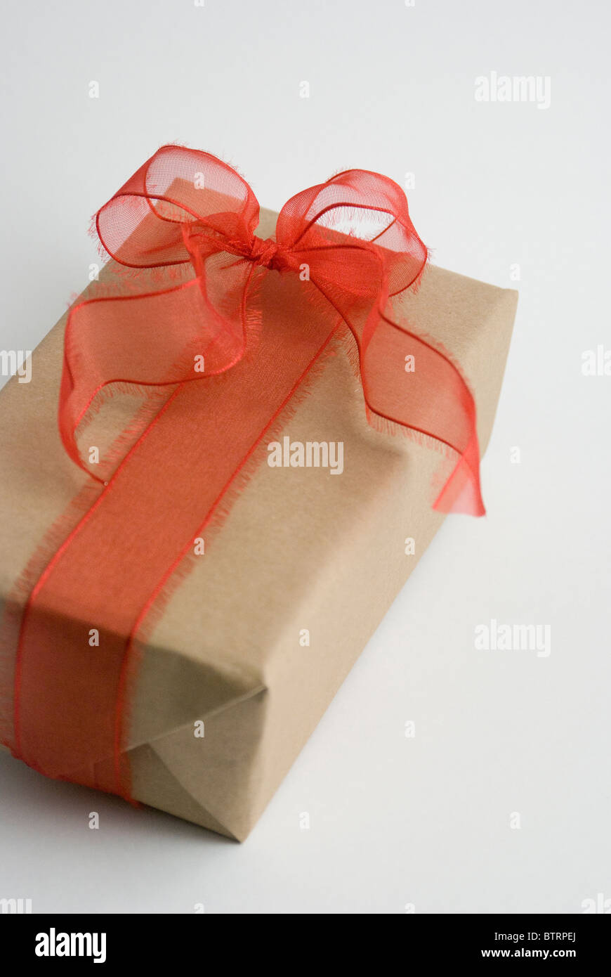 Brown paper wrapped box with red ribbon bow Stock Photo - Alamy