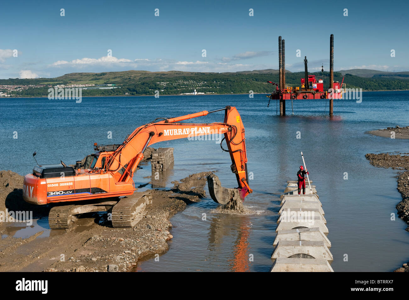 Large digger building sea defences at Dunoon, Argyll Stock Photo - Alamy