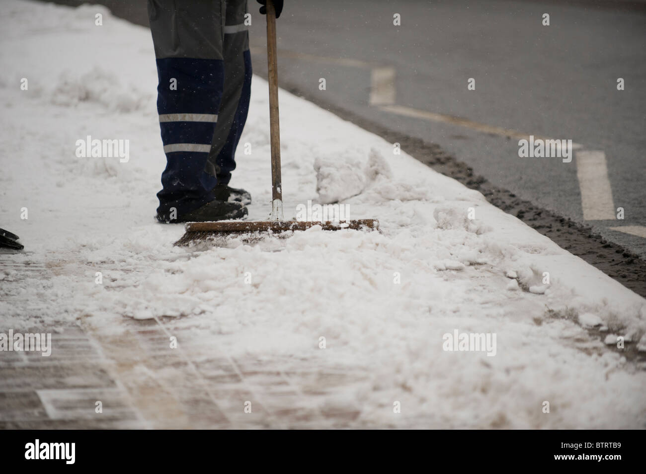 Local authority workers clear snow and ice off the pavement Stock Photo ...