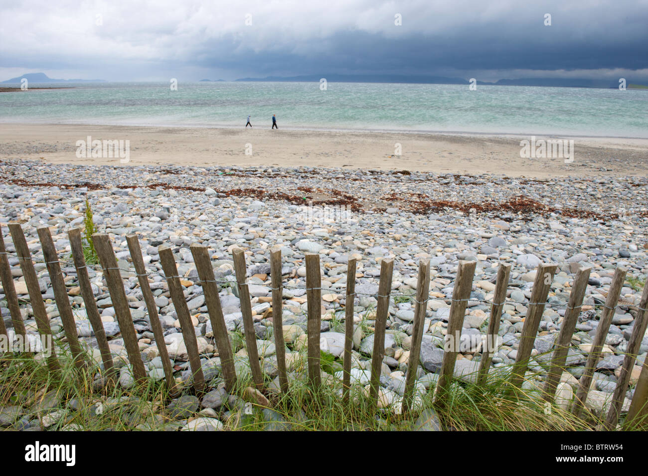 Storm clouds over walkers on Bertra beach with a view of Clare Island ...