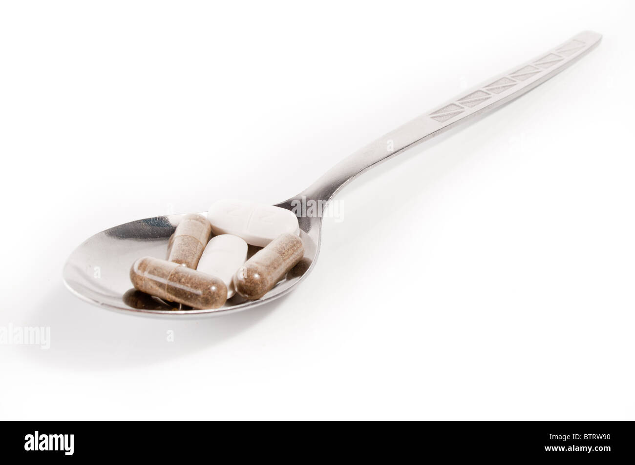 Spoon of tablets Stock Photo - Alamy