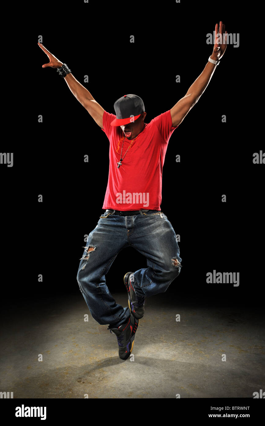 African American hip hop dancer performing over dark background with ...
