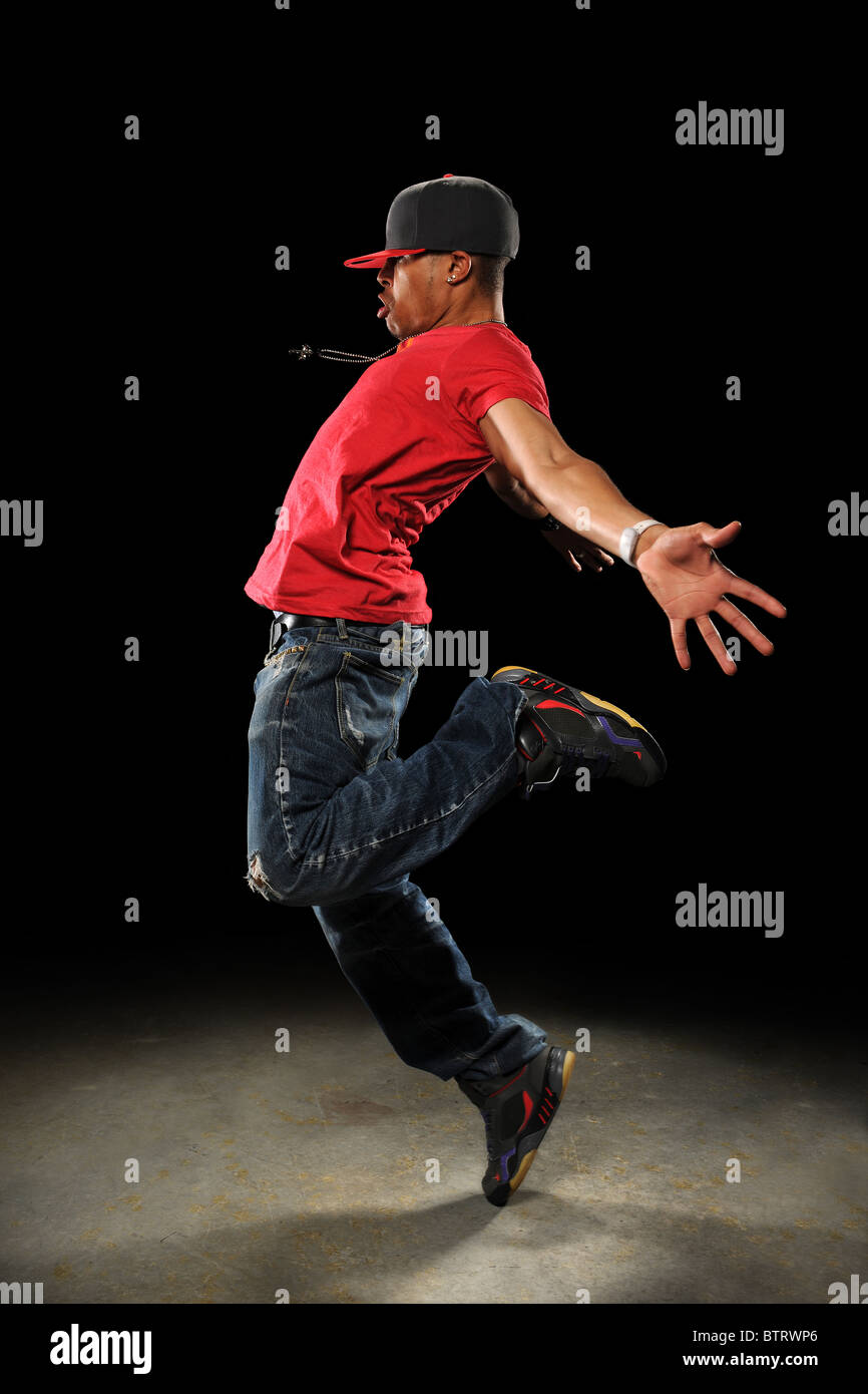 African American hip hop dancer performing over dark background with ...